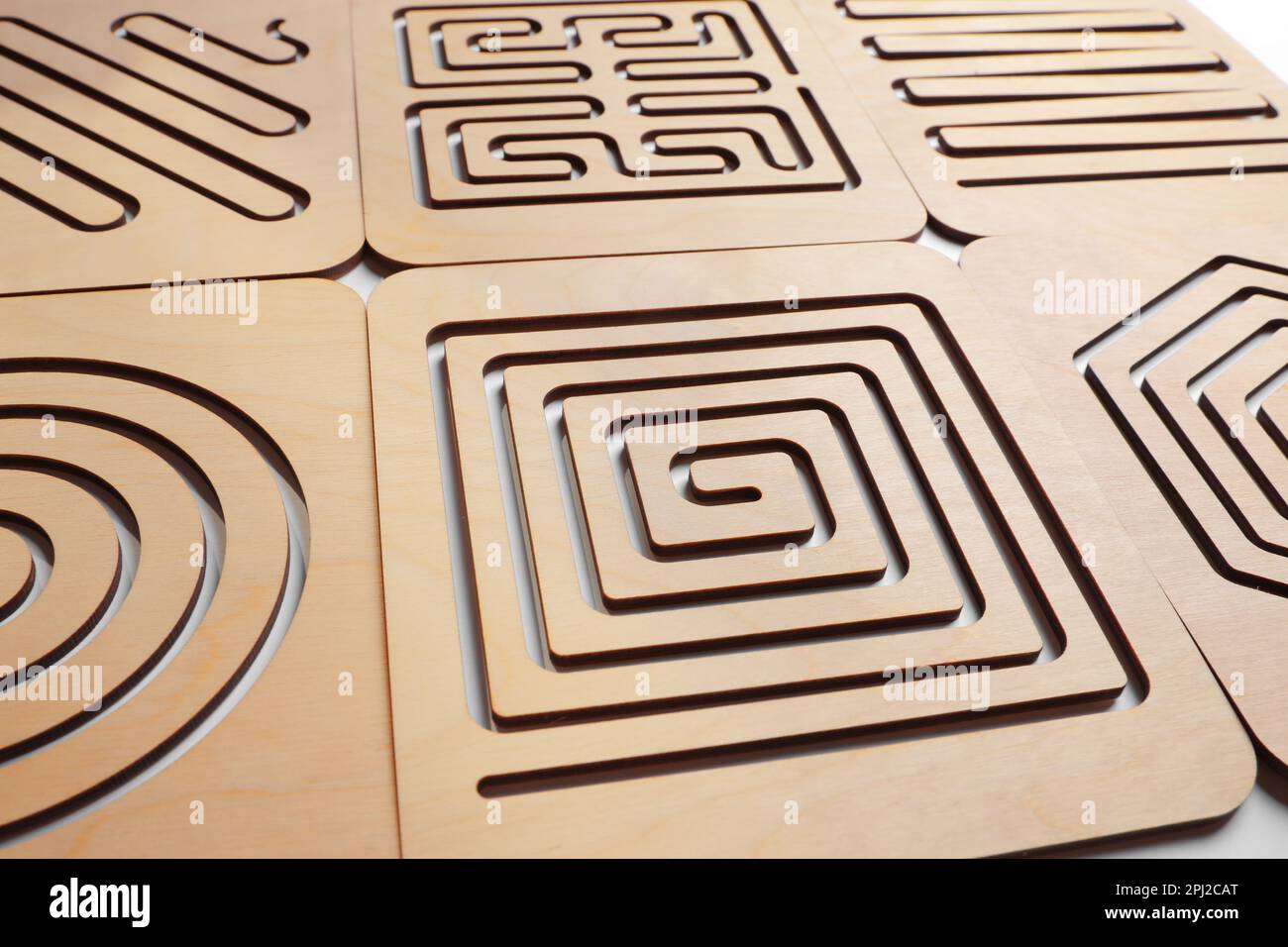 Wooden finger labyrinths on white background, closeup. Montessori toy ...