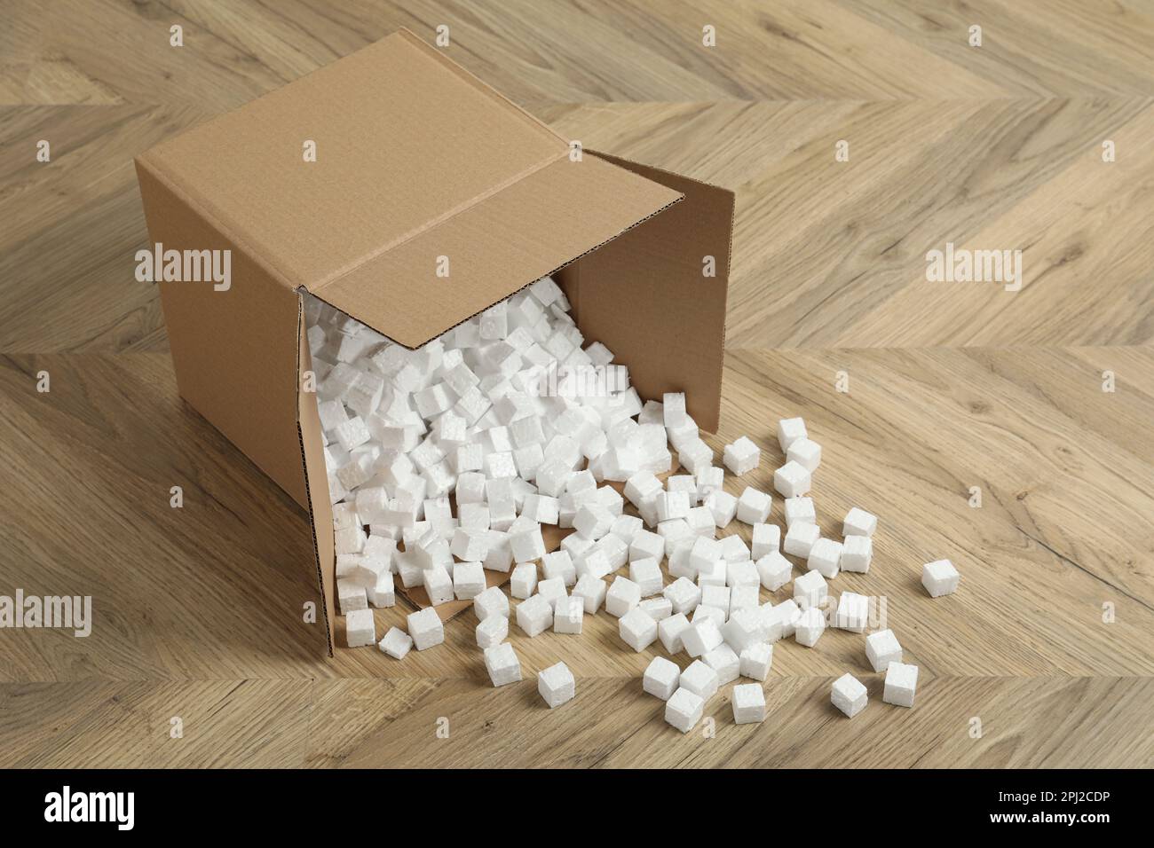 Overturned cardboard box with styrofoam cubes on wooden floor Stock ...