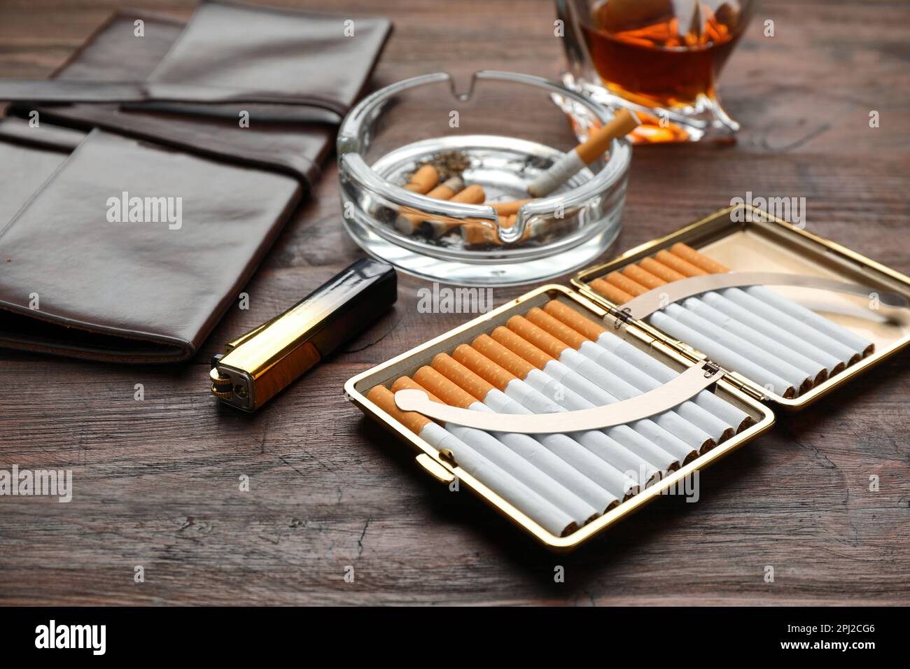 Open case with tobacco filter cigarettes, glass ashtray, lighter ...