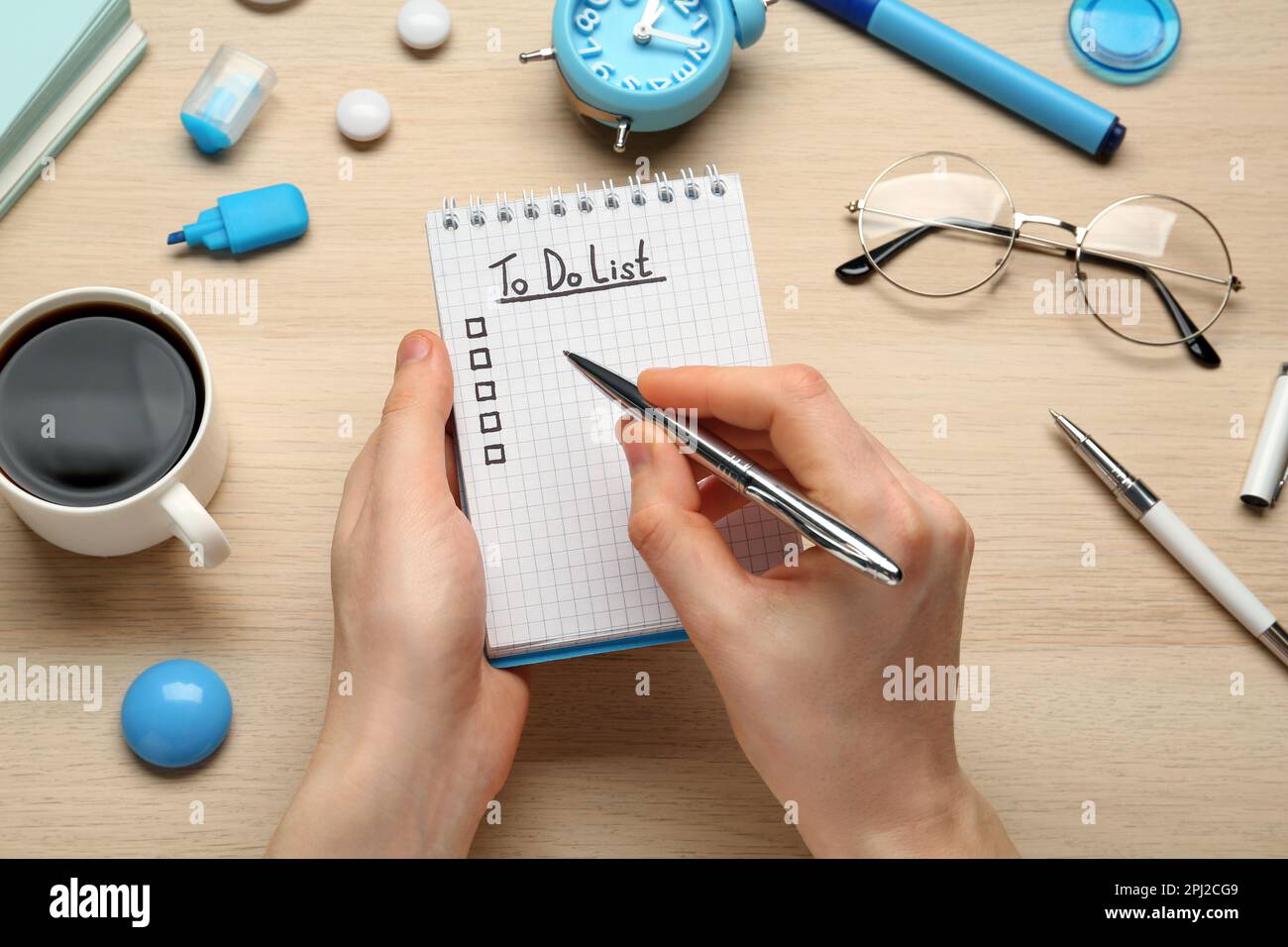 Woman filling To Do list in notepad at wooden table, top view Stock ...
