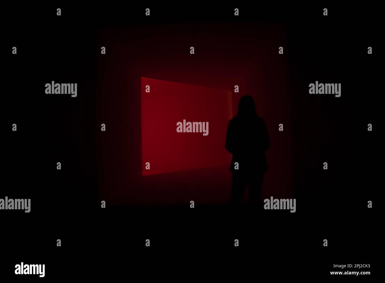Shadowy figure on the dark background with red light Stock Photo - Alamy