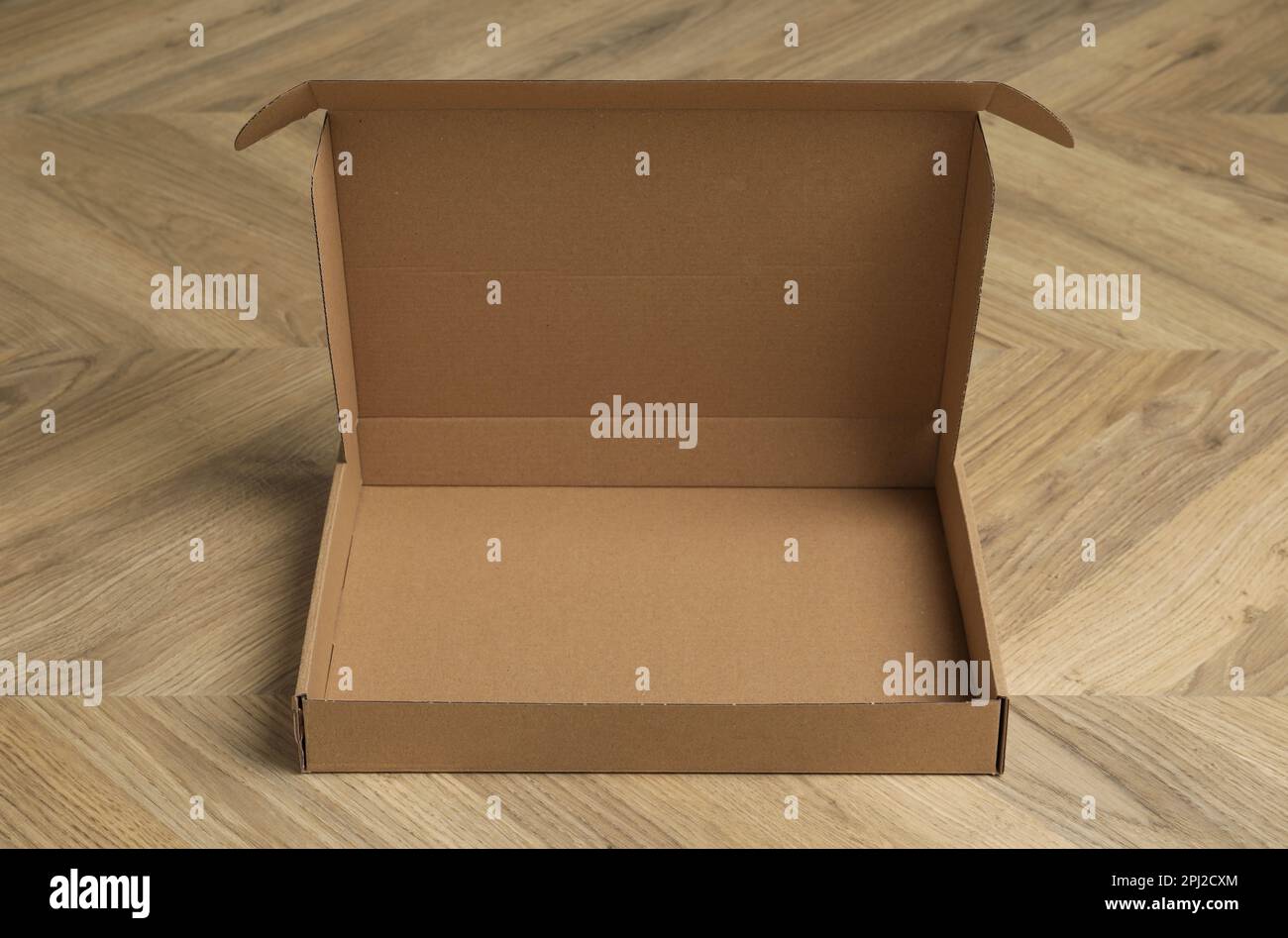 One empty open cardboard box on floor Stock Photo - Alamy