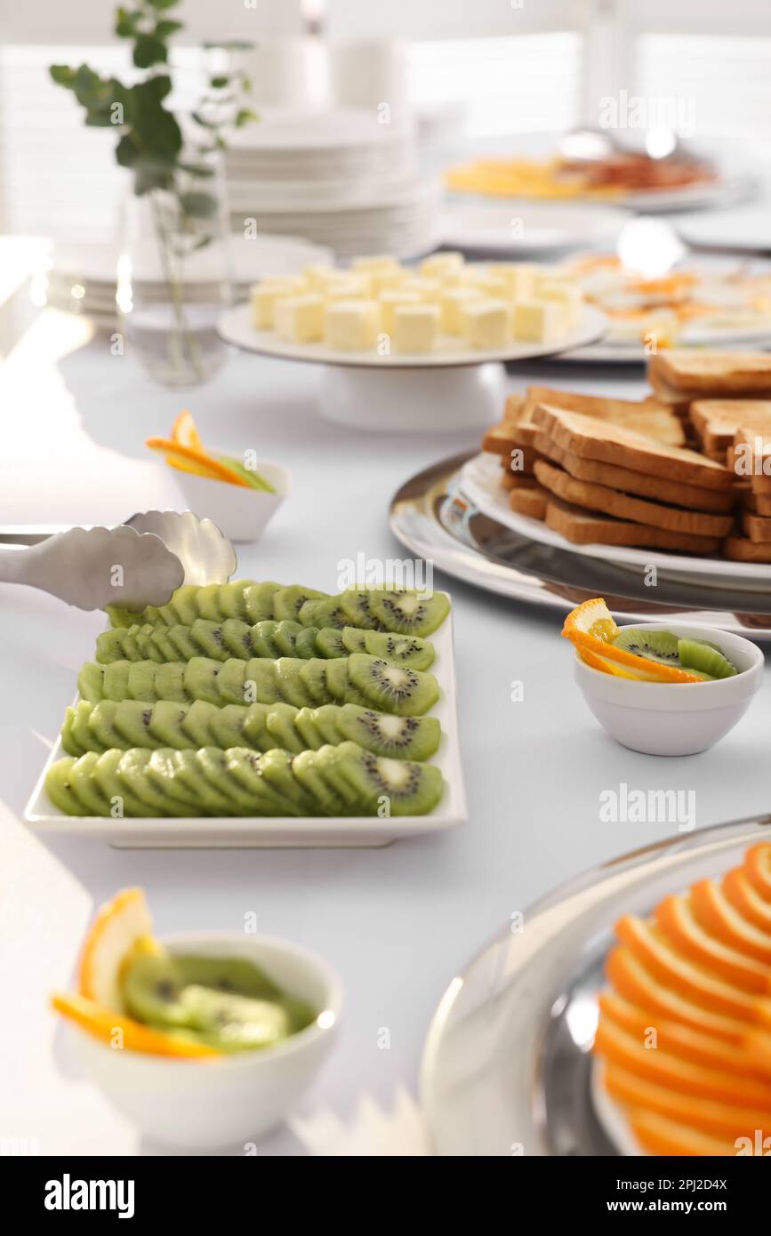 Different meals for breakfast on white table indoors. Buffet service ...
