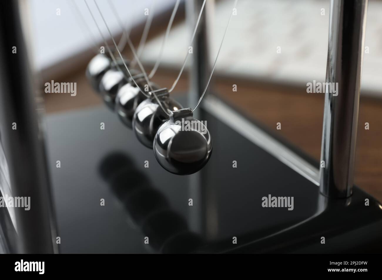 Newton's cradle on table, closeup. Physics law of energy conservation ...