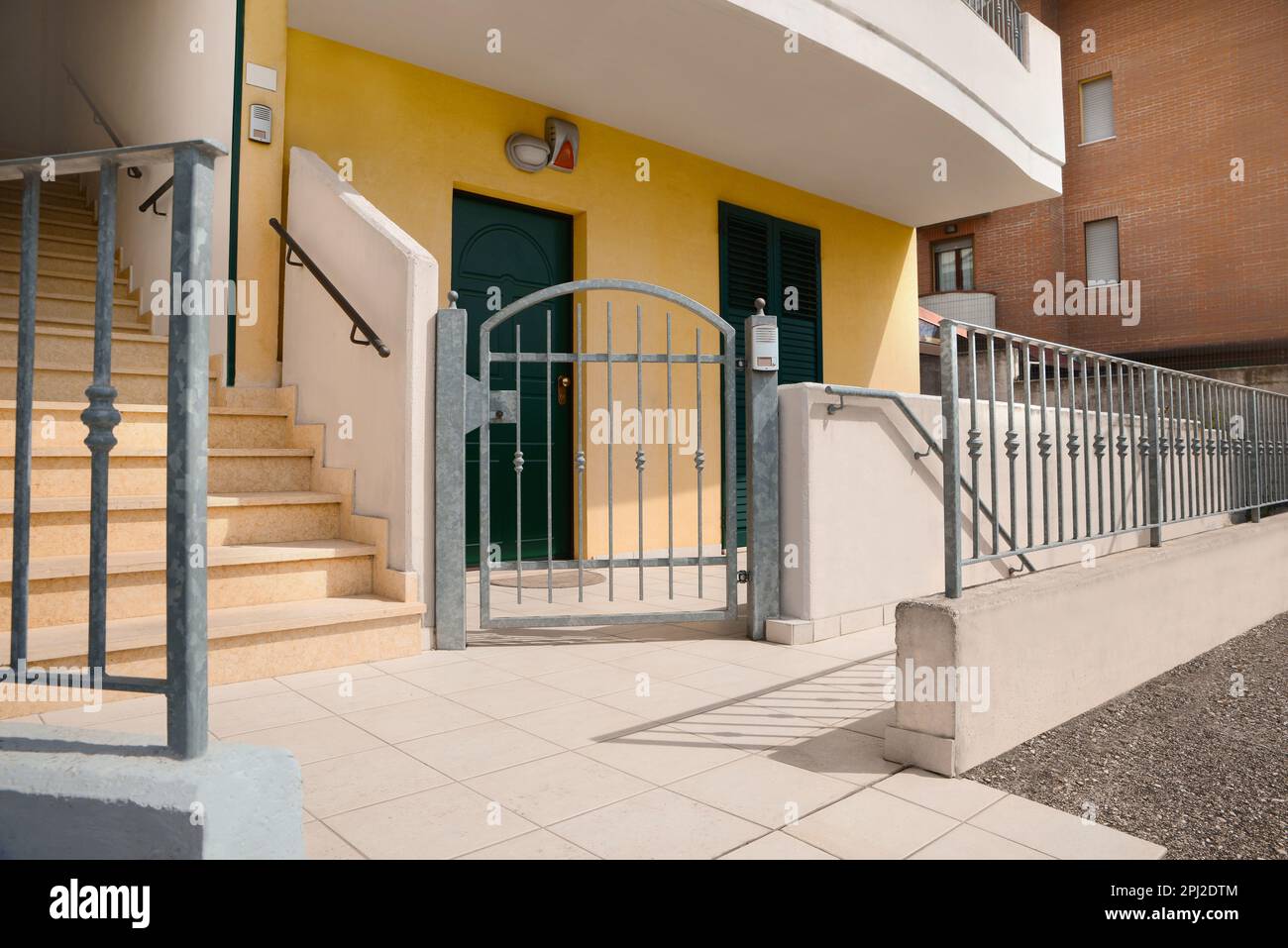 Stylish building entrance with intercom on metal gate Stock Photo - Alamy