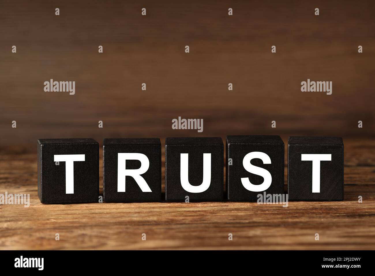 Black cubes with word TRUST on wooden table. Space for text Stock Photo ...