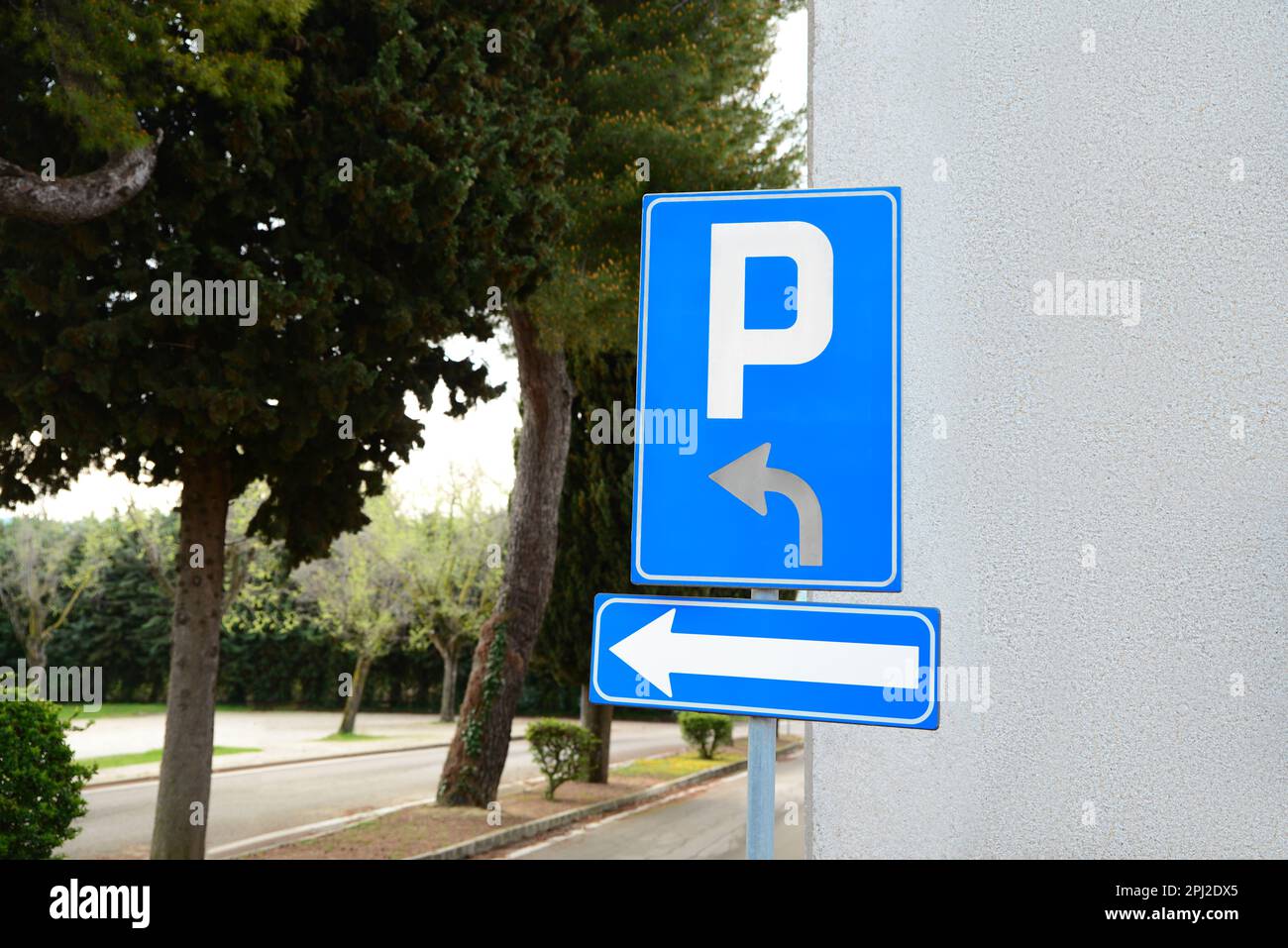 Post with traffic signs on city street Stock Photo - Alamy