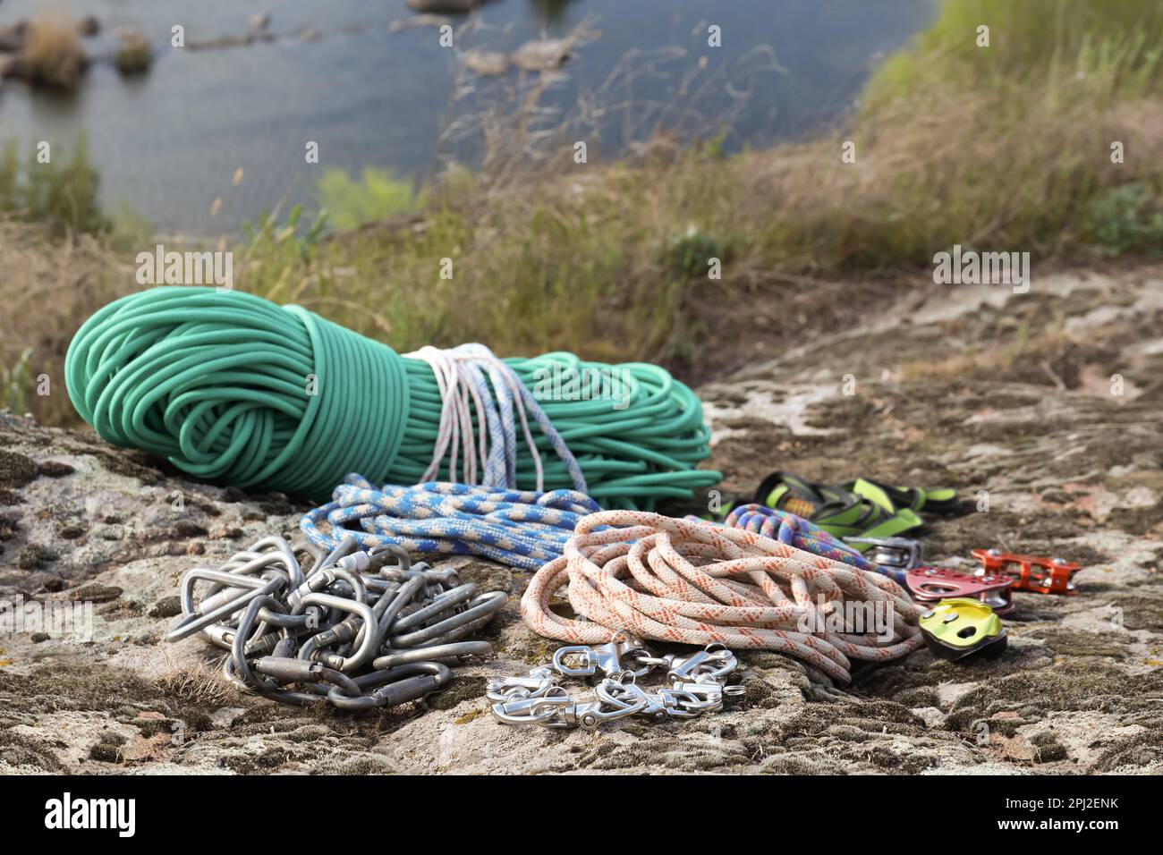 Different ropes and other climbing equipment on rock near river Stock ...