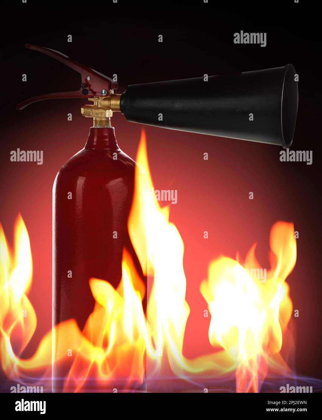 Fire extinguisher surrounded by flame on dark background Stock Photo ...