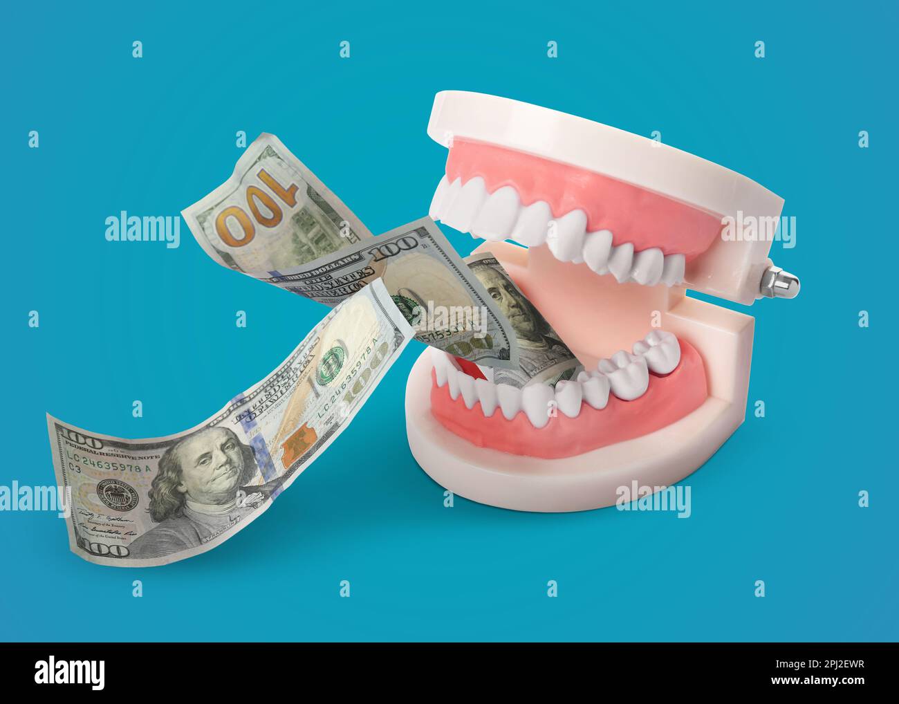 Model of oral cavity with teeth and dollar banknotes on turquoise ...