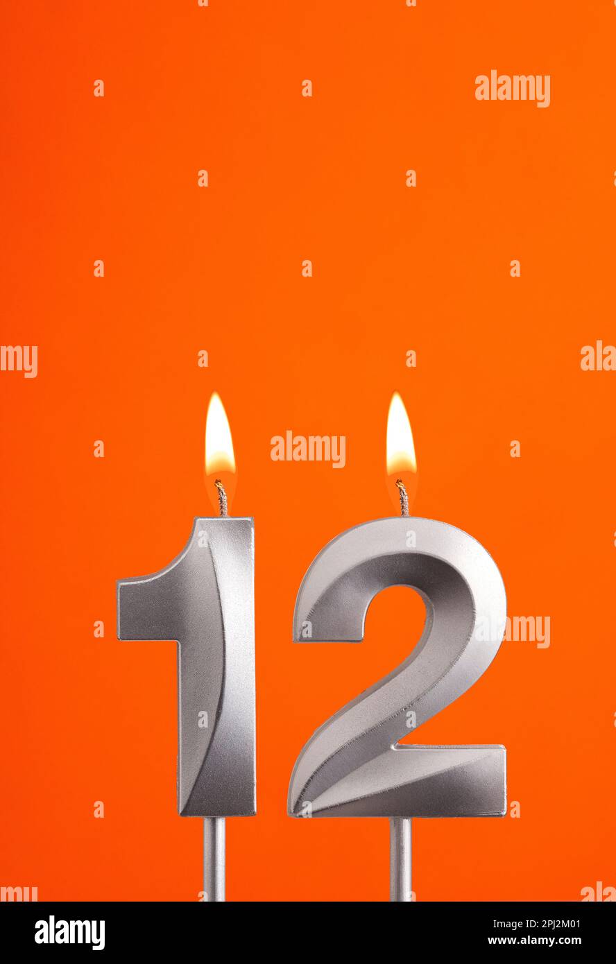 Candle number 12 - Birthday in orange foamy background Stock Photo - Alamy