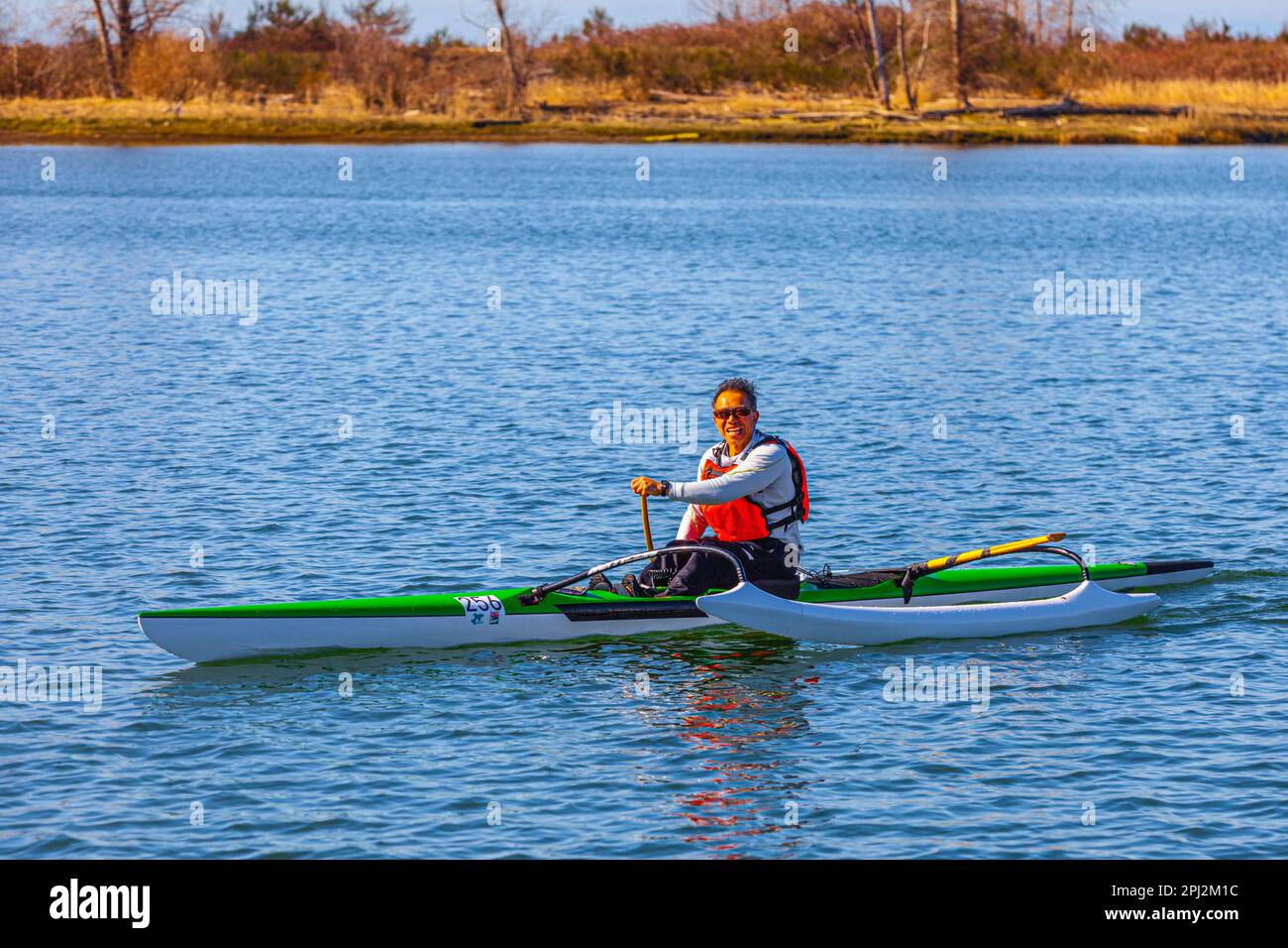Man in an outrigger kayak paddling in Steveston Inlet British Columbia ...