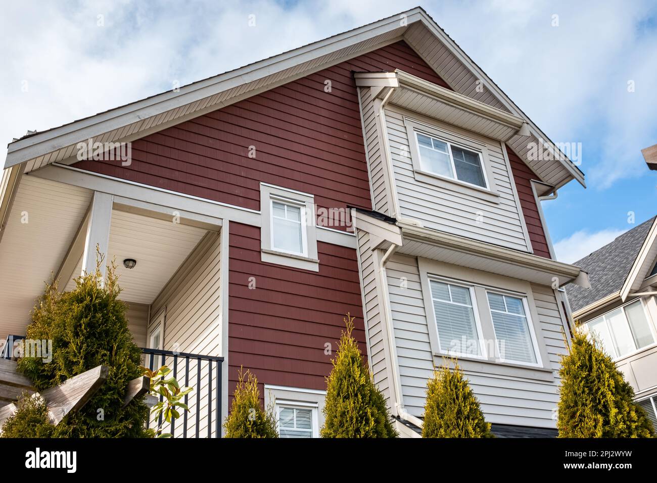Top of a house with nice windows. Dormer in the blue sky background ...