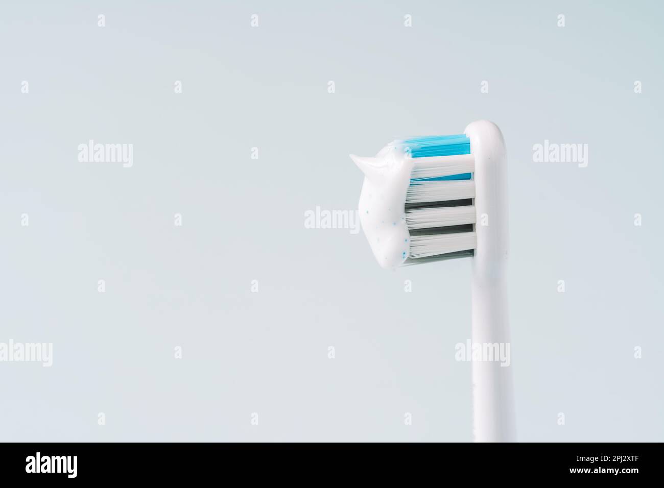 Electric toothbrush head with toothpaste against blue background Stock ...