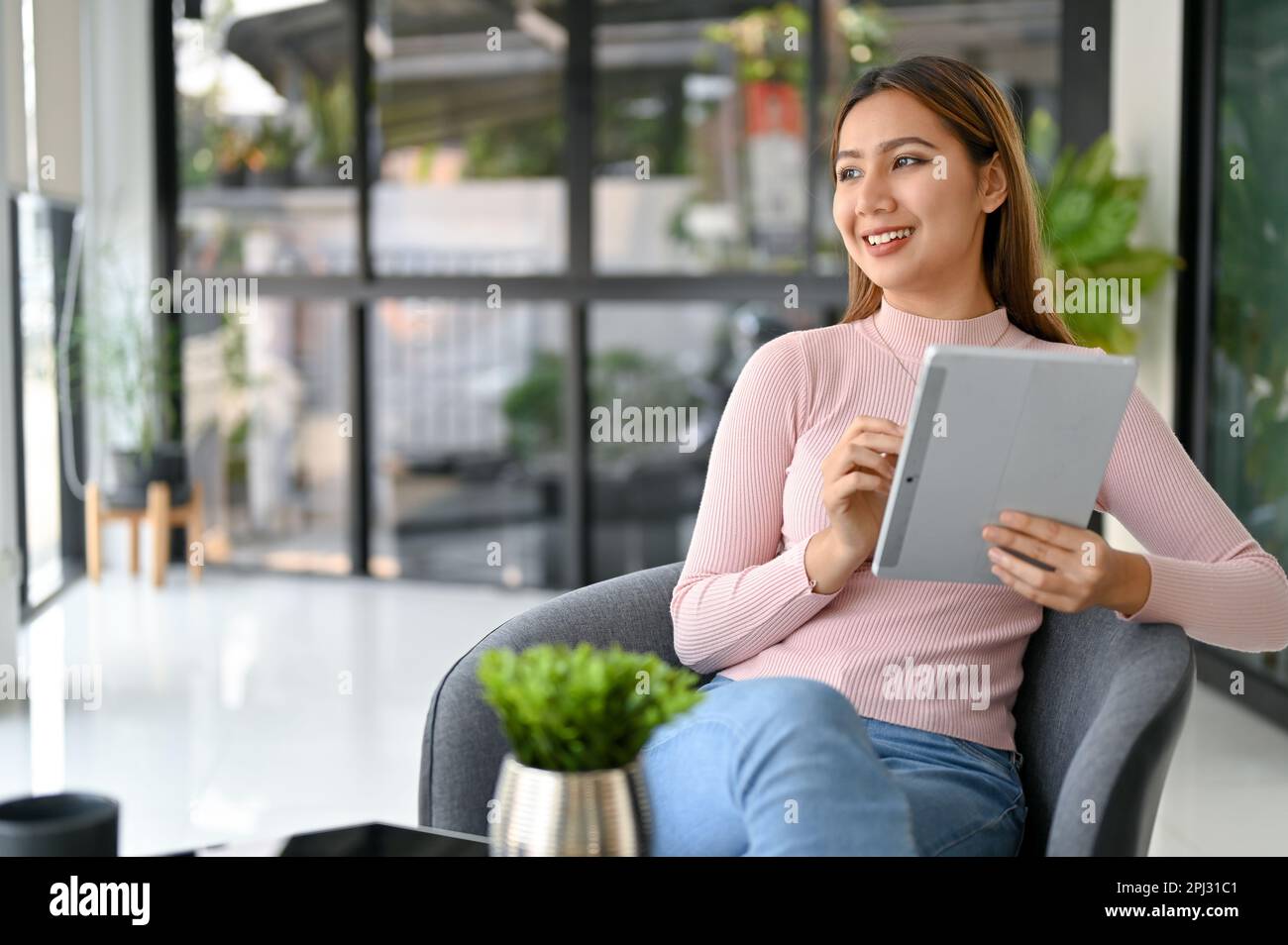 Charming and inspired millennial Asian female freelancer looks out the ...
