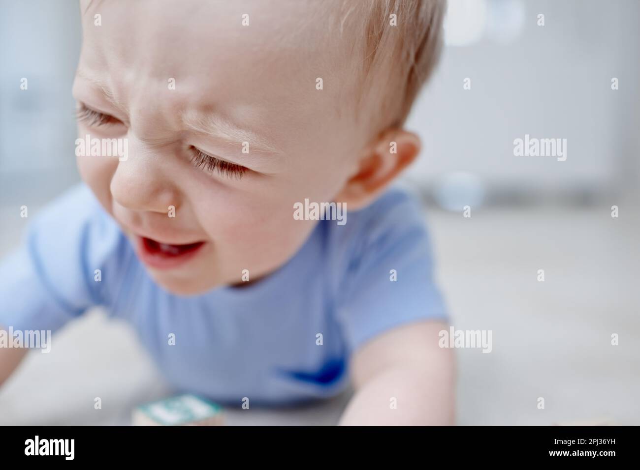 Playtime is over. Closeup of a crying baby boy lying on the floor Stock ...