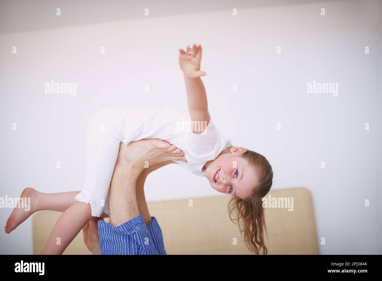 Fun times with her father. Side view of a young girl propped up on her ...