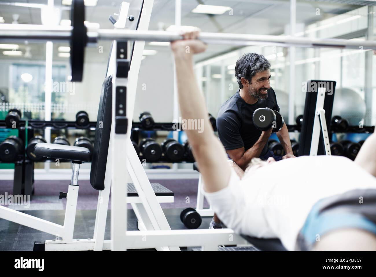 Its all smiles in the gym. two men lifting weights in the gym Stock ...