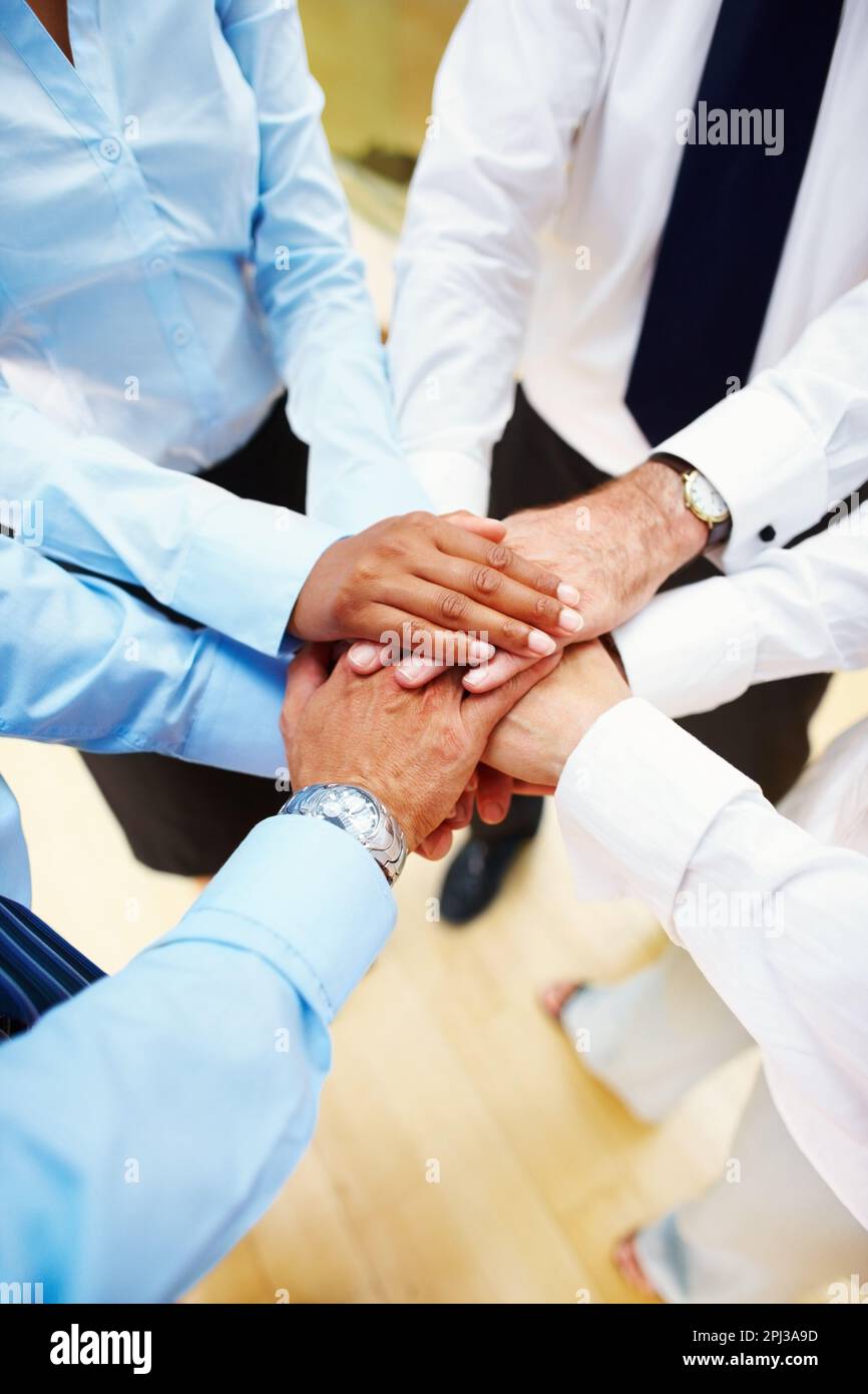 Teamwork is powerful. Team of executives with hands on top of one ...