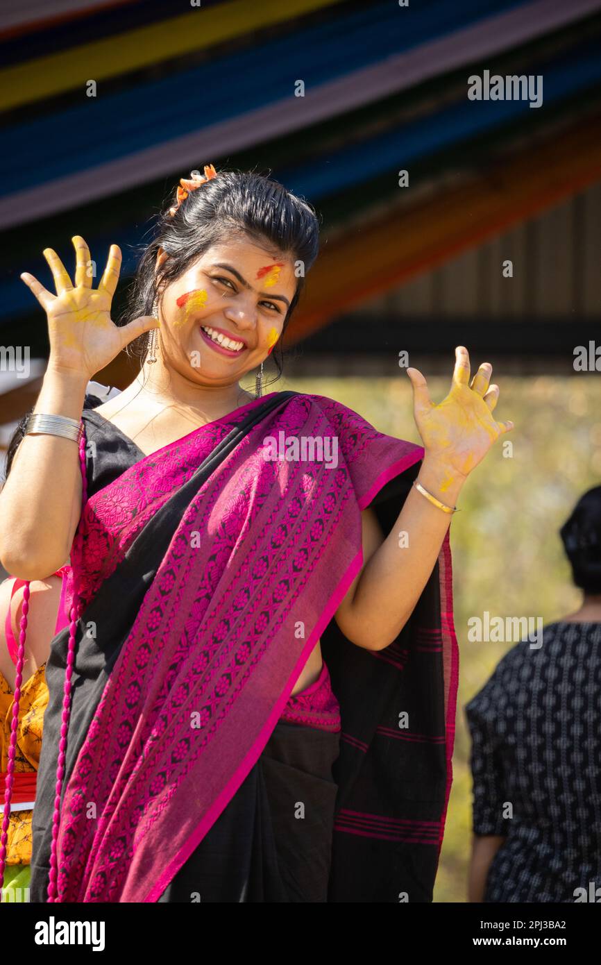 An Indian woman with colorful face looking at camera in holi - the ...