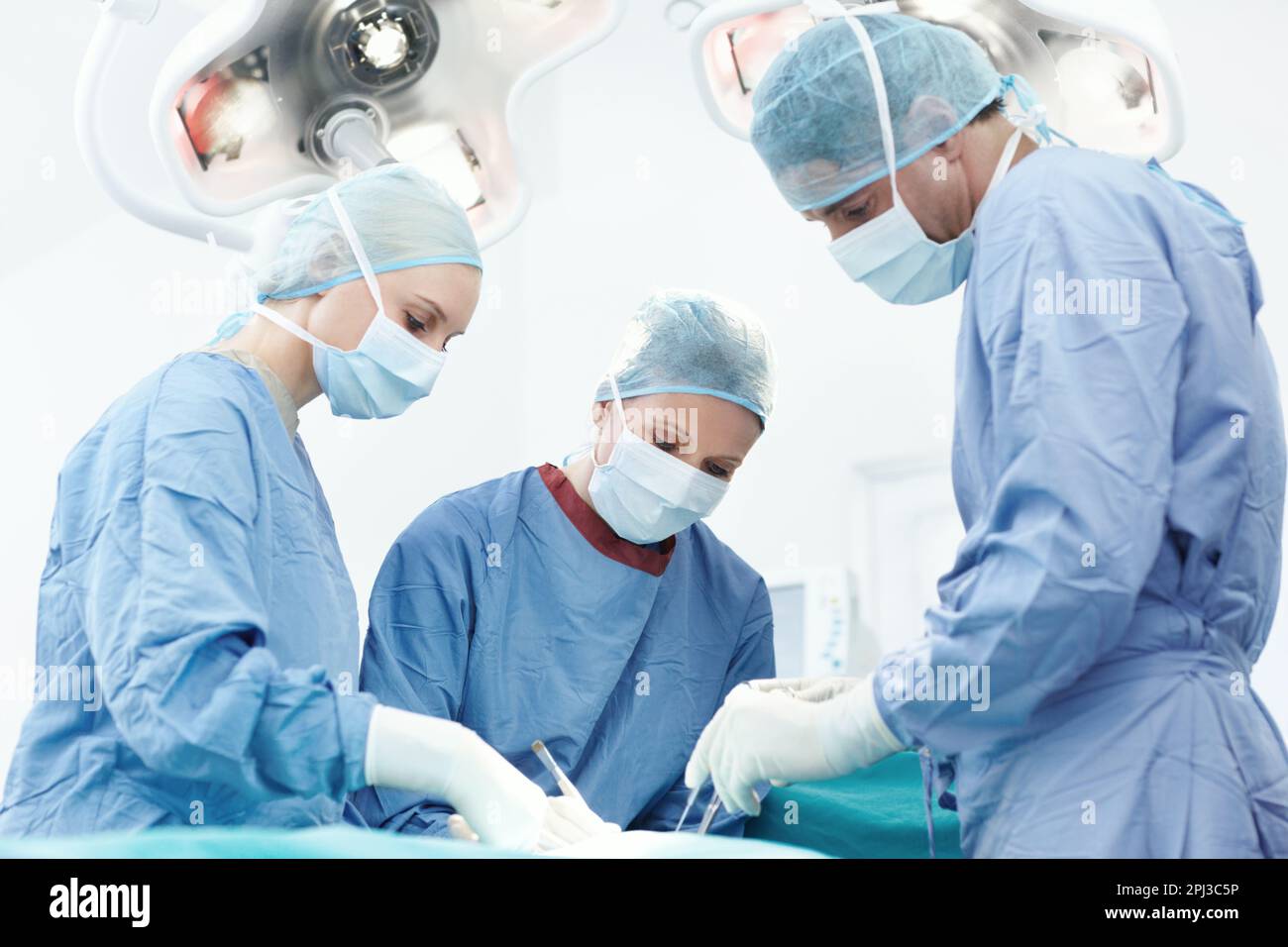 Helping hands. Medical surgeons working together in an operating ...