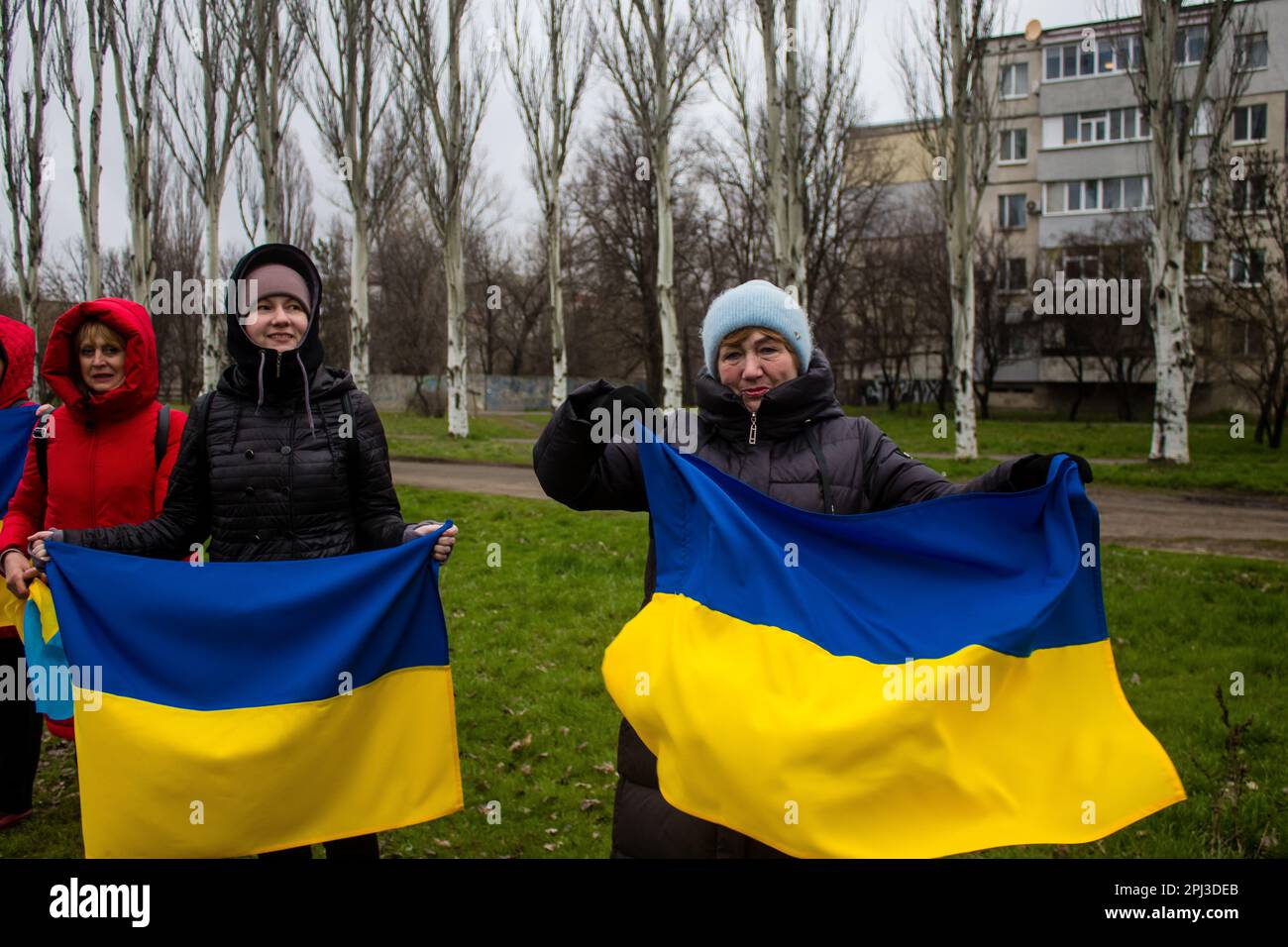 Women gather by the side of the road with Ukrainian flags to encourage ...