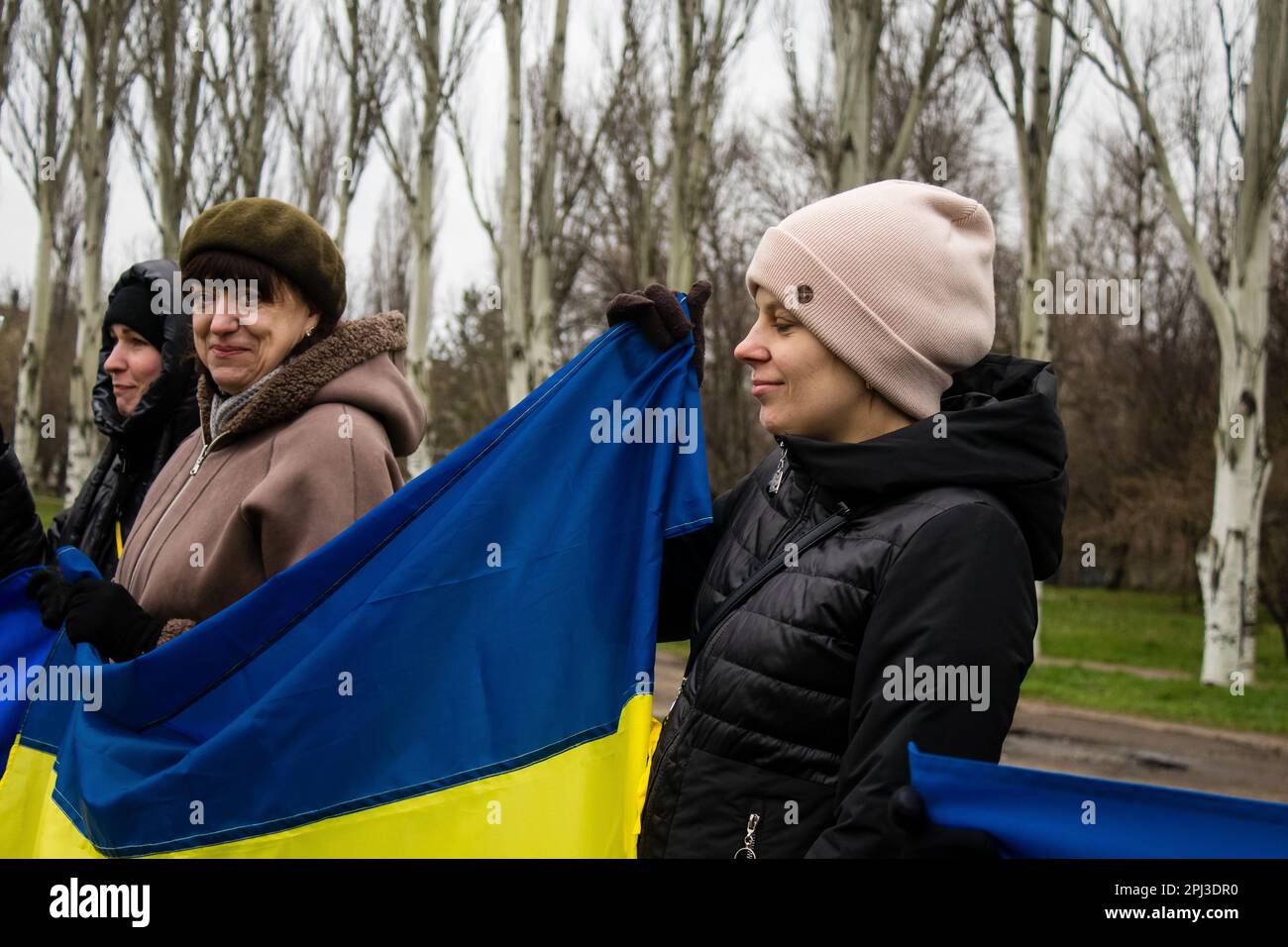 Women gather by the side of the road with Ukrainian flags to encourage ...