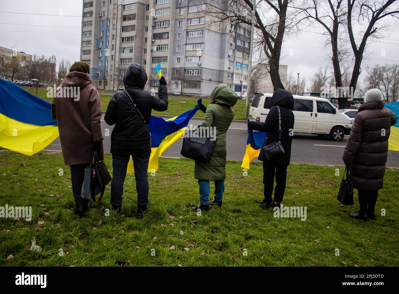 Women gather by the side of the road with Ukrainian flags to encourage ...