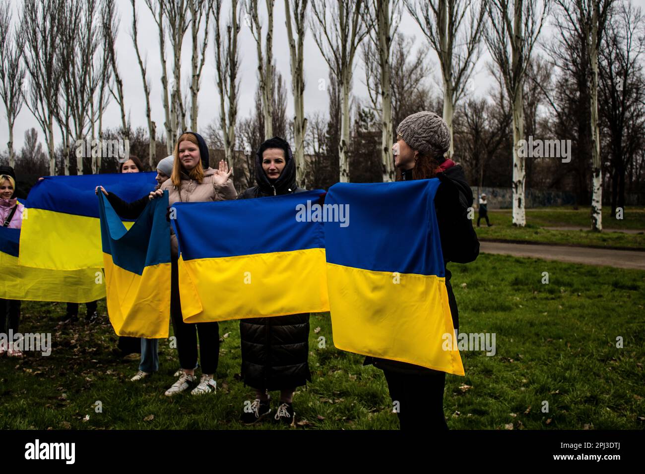 Women gather by the side of the road with Ukrainian flags to encourage ...