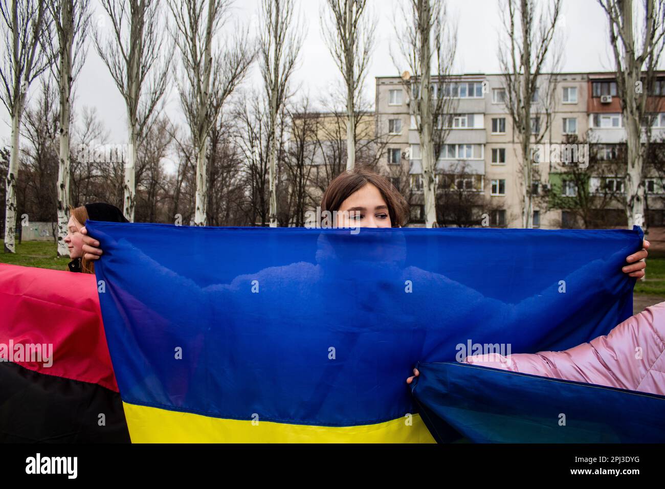 Women gather by the side of the road with Ukrainian flags to encourage ...