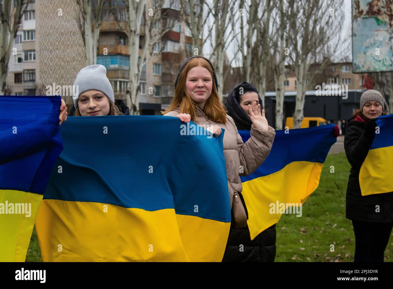 Women gather by the side of the road with Ukrainian flags to encourage ...