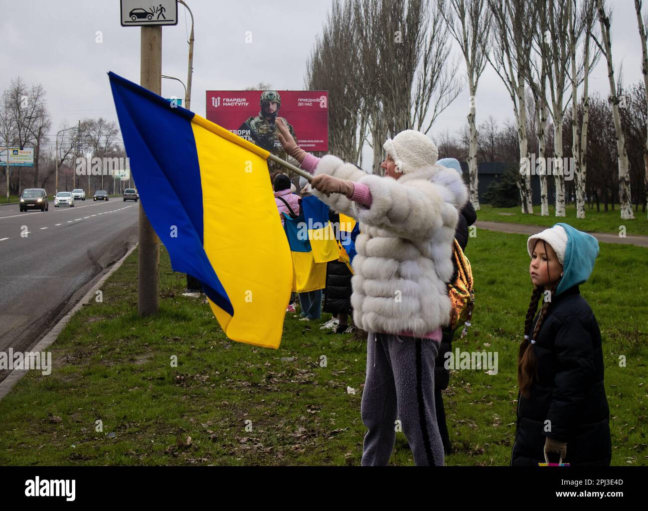 Women gather by the side of the road with Ukrainian flags to encourage ...