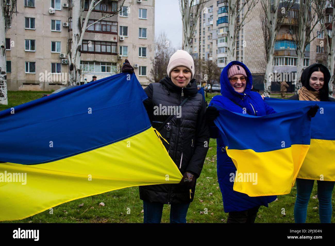 Women gather by the side of the road with Ukrainian flags to encourage ...