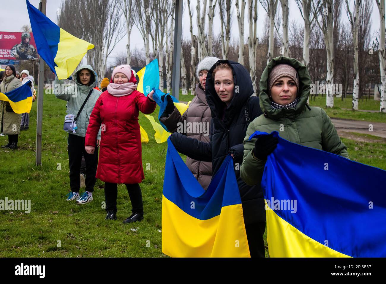 Women gather by the side of the road with Ukrainian flags to encourage ...