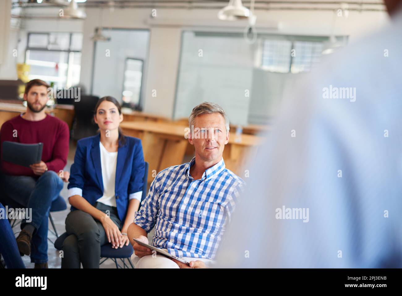 Listen to those who know. A group of colleagues listening to a ...
