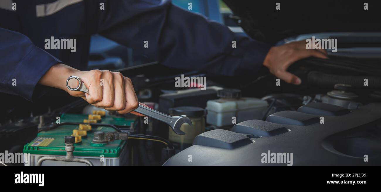 The mechanic works on the engine of the car in the garage, car repair ...