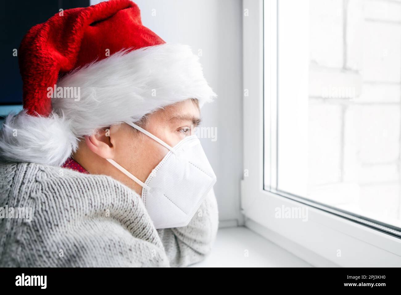 Sad Young Man in Santa Hat and Flu Mask by the Window closeup Stock ...