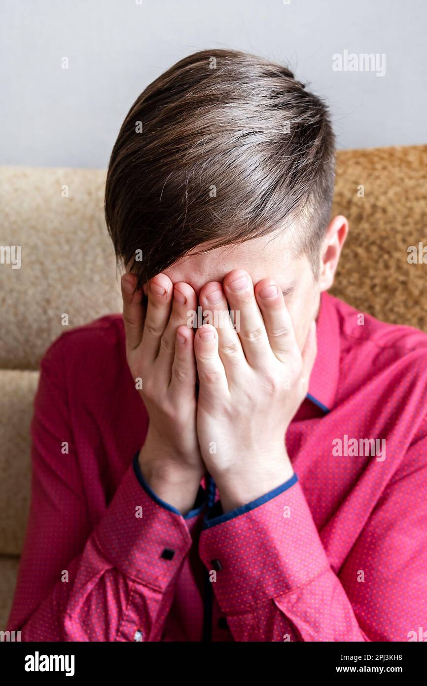 Sad Young Man is Crying on the Sofa by the Wall in the Room Stock Photo ...