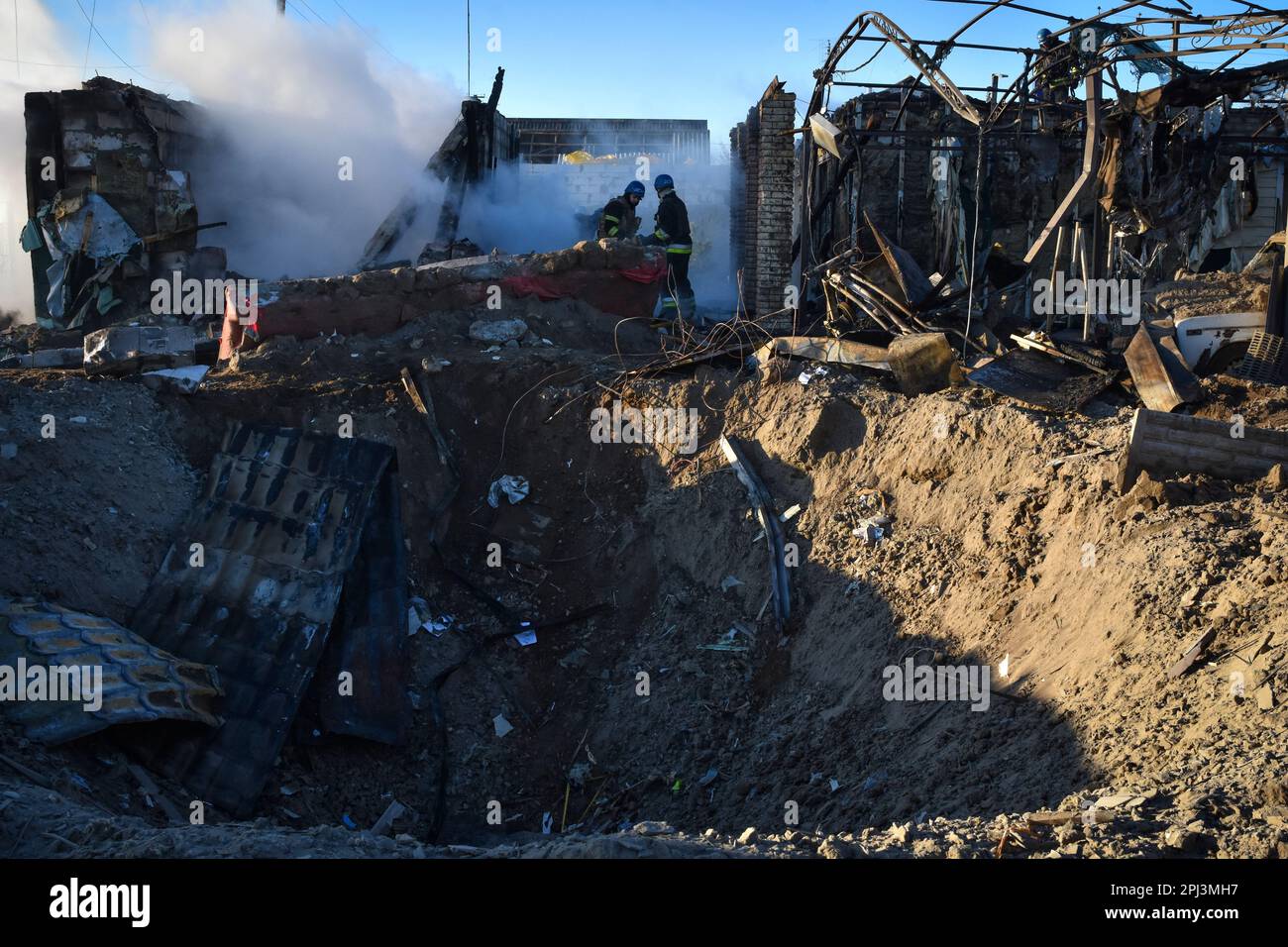 Members of the Ukrainian State Emergency Service clear the rubble at ...