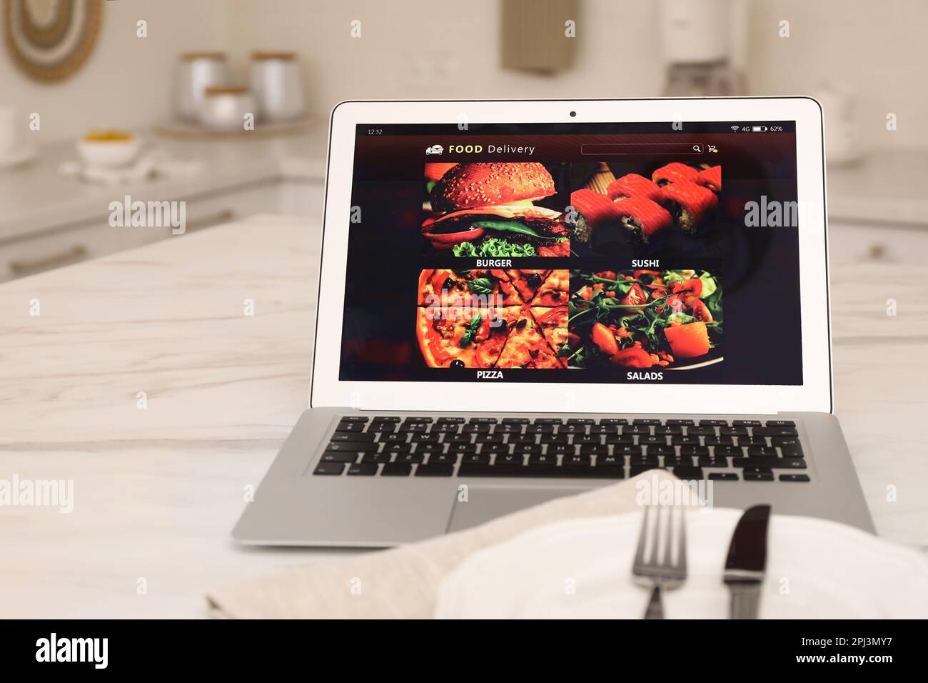 Modern laptop with open page for online food ordering on table in ...