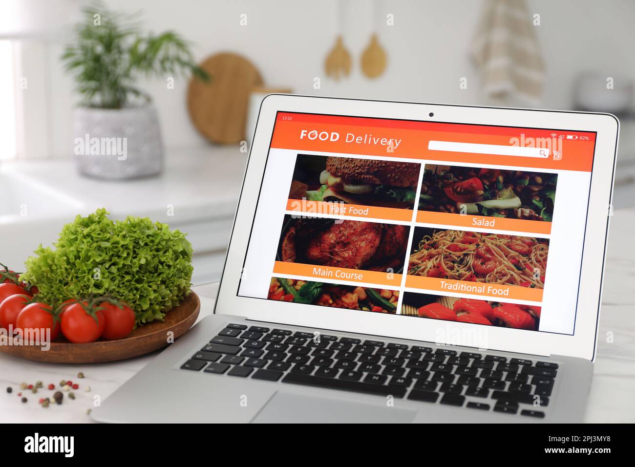 Modern laptop with open page for online food ordering on table in ...