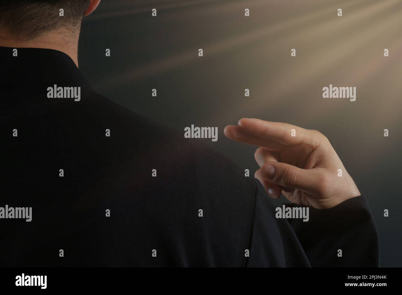 Holy light and priest making cross sign on black background, closeup ...