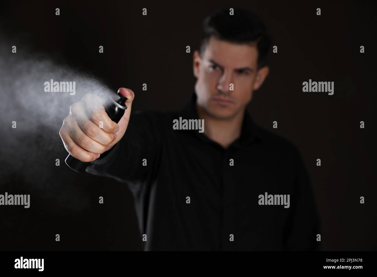 Man using pepper spray against black background, focus on hand Stock ...