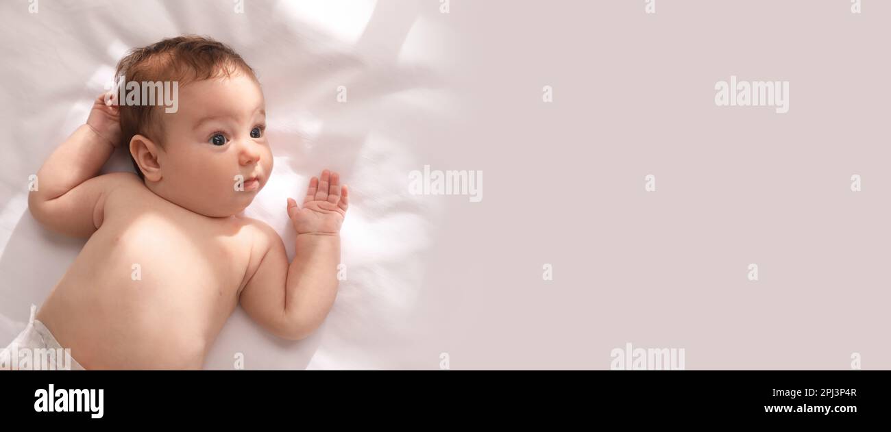 Cute little baby on bed, top view with space for text. Banner design ...