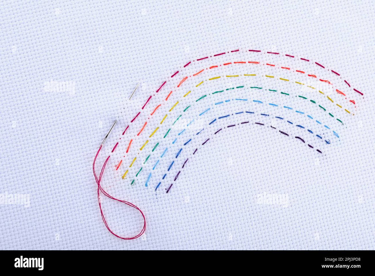 Canvas with embroidered rainbow and needle, top view Stock Photo - Alamy