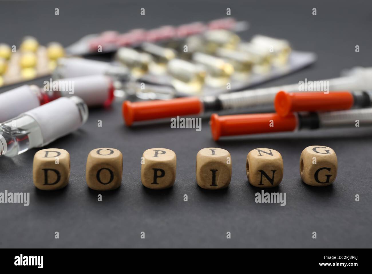Wooden cubes with word Doping and drugs on black background, closeup ...