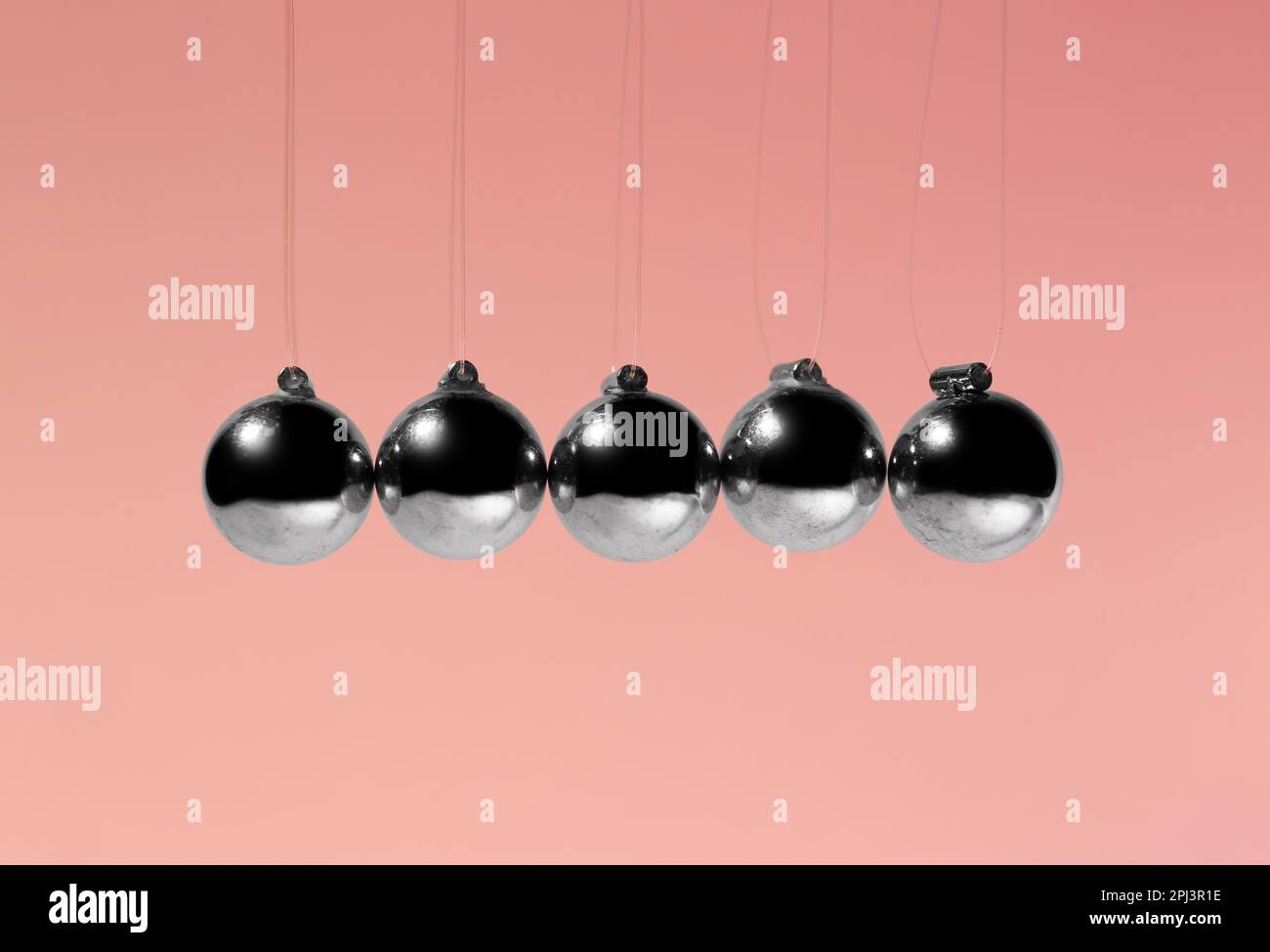 Newton's cradle on pink background. Physics law of energy conservation ...