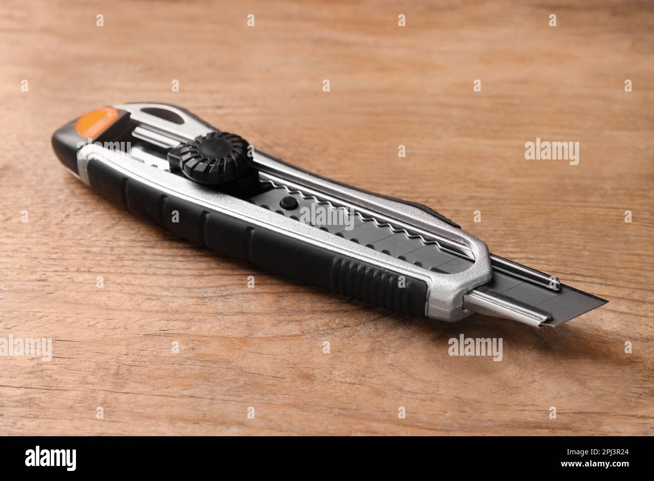 Utility knife on wooden table, closeup. Construction tool Stock Photo ...