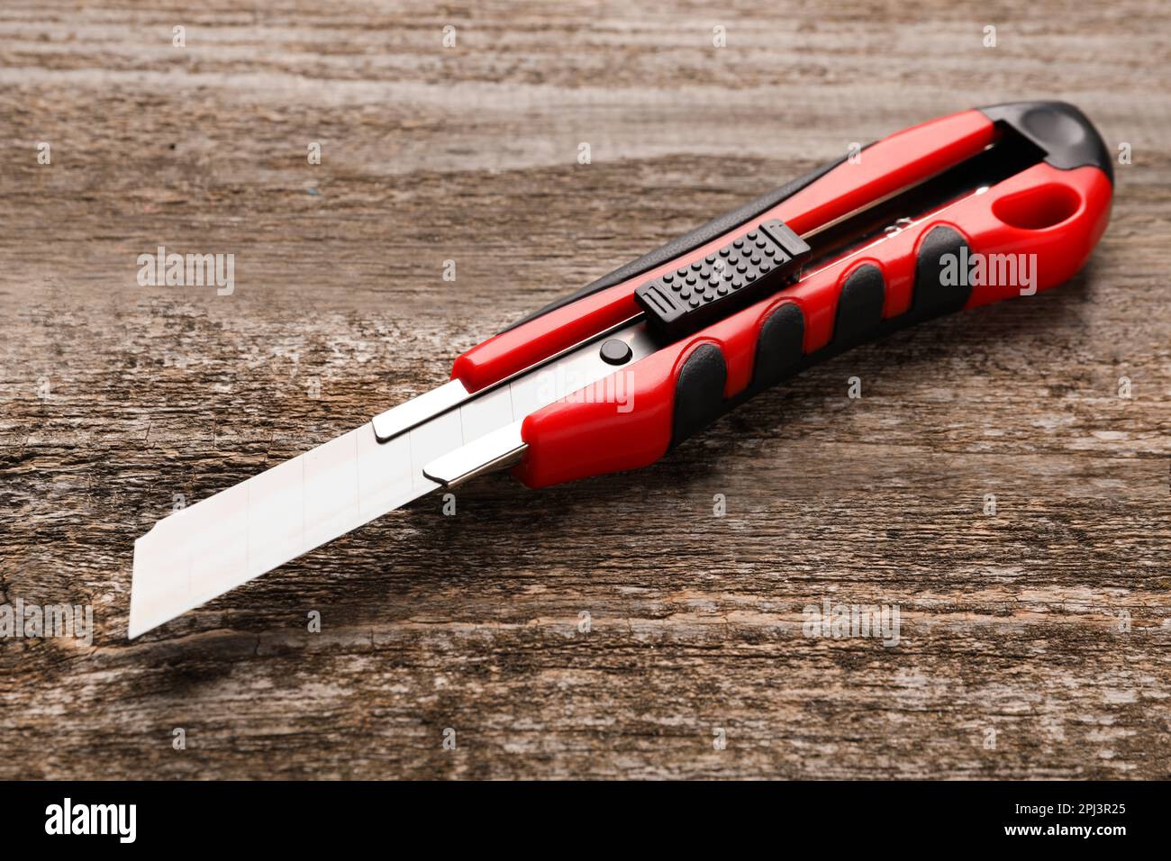 Utility knife on wooden table. Construction tool Stock Photo - Alamy