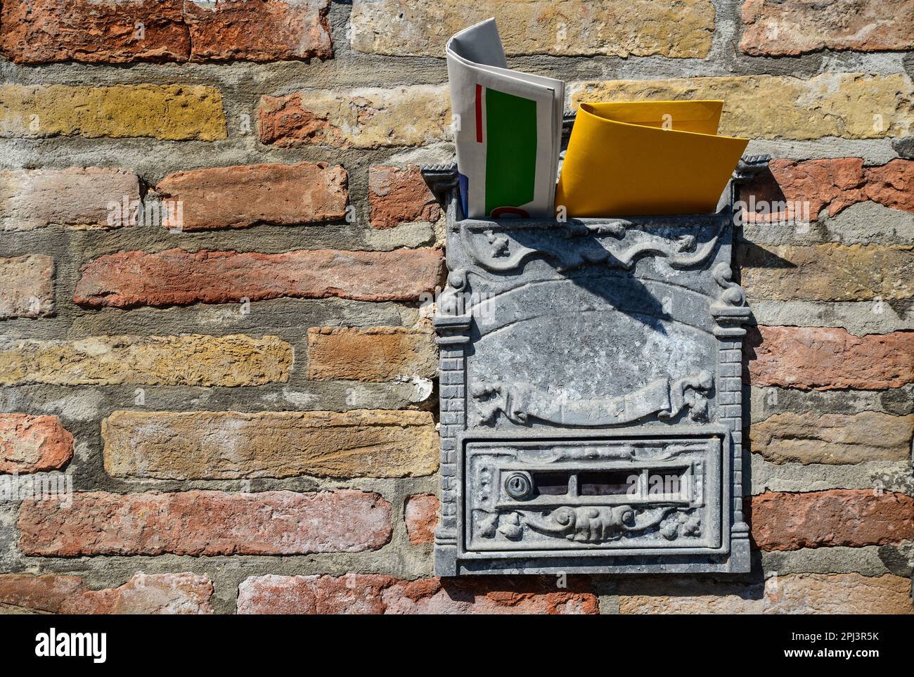 Vintage post box with newspaper and letter on old brick wall. Space for ...